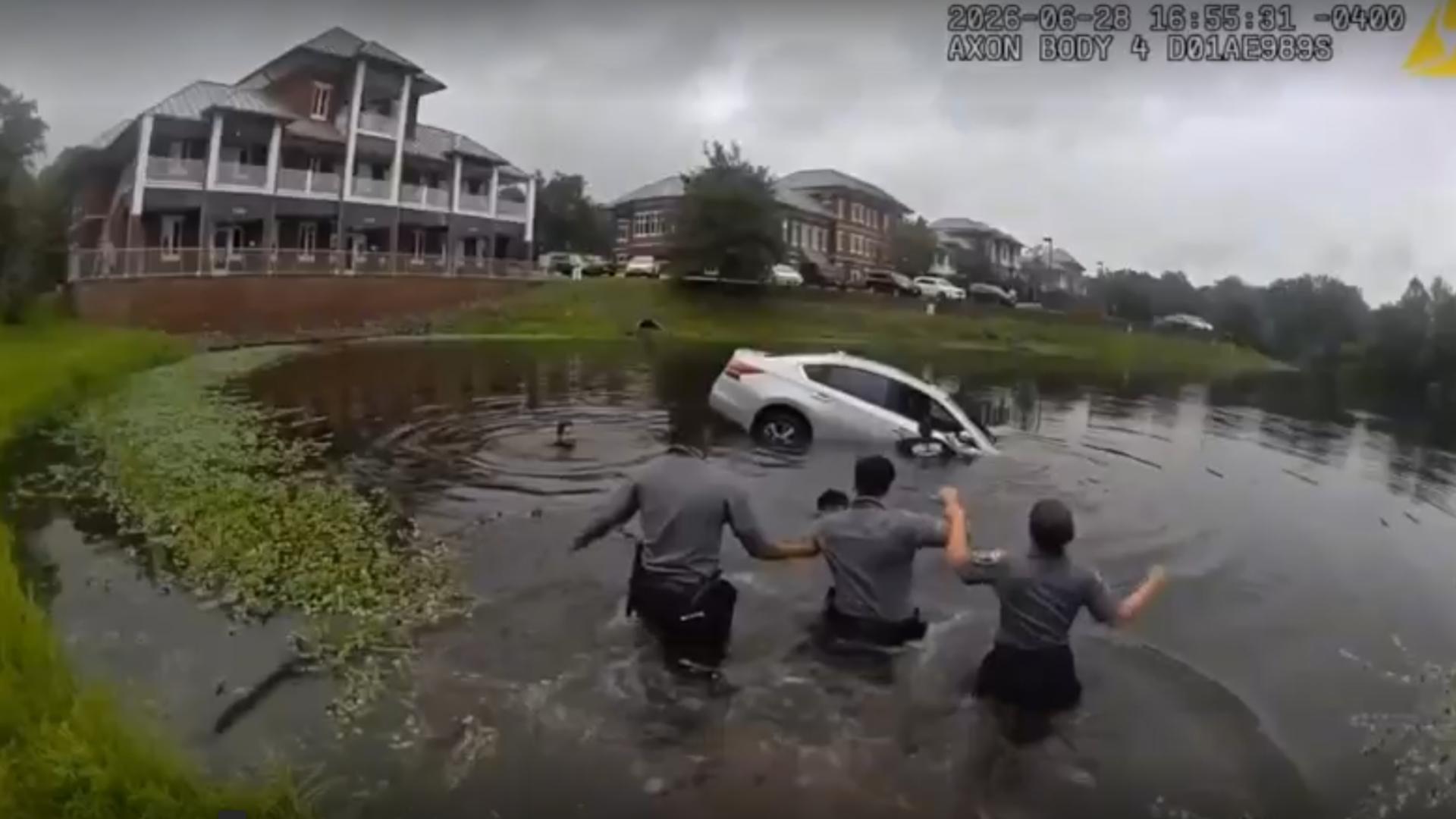 WATCH: Officers form human chain to rescue driver trapped in a sinking ...